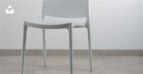 흰 벽 근처의 흰색 팔걸이없는 의자 사진 Unsplash의 무료 의자 이미지