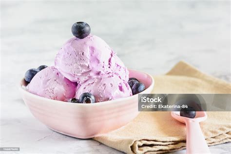 그릇에 블루 베리와 보라색 달콤한 아이스크림 보라색 꽃병에 과일을 곁들인 아이스크림 세 덩어리 프로스팅 소르베의 일부 숟가락에 베리 맛있는 냉동 접시 프로스팅 크리미 디저트