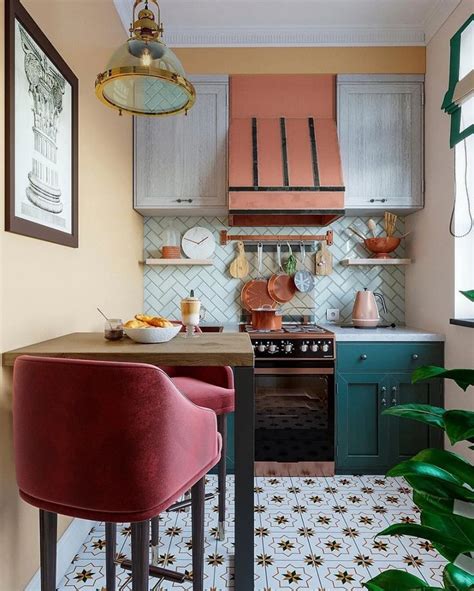 a kitchen with green cabinets and pink chairs