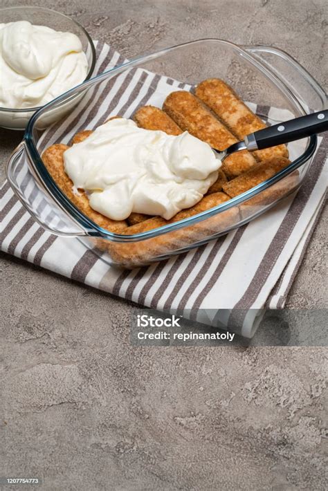 티라미수 디저트 요리 전통적인 이탈리아 사보이아르디 레이디 핑거 비스킷과 콘크리트 배경에 유리 베이킹 접시에 크림 0명에 대한