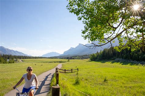 산악 초원을 통과하는 포장 된 길을 따라 순양함 자전거를 타는 여성 55 59세에 대한 스톡 사진 및 기타 이미지 55 59세 개성 개념 건강한 생활방식 Istock