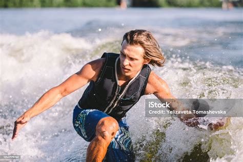 아름다운 긴 머리 금발 웨이크 서핑 호수의 파도를 따라 보드에 조끼 육상 남성 선수는 강에서 여름에 서핑을 깨워 웨이크 서핑 수상 스포츠 파도에 서퍼 서핑보드에서 서핑하는