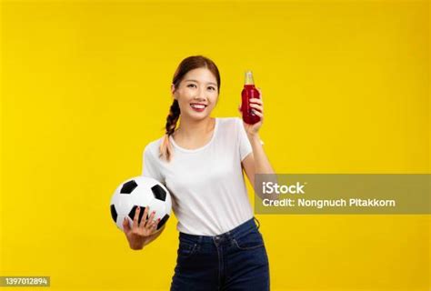 고립 된 노란색 배경에 축구 공과 음료를 들고 아시아 여성 스포츠 개념 T 25 29세에 대한 스톡 사진 및 기타 이미지