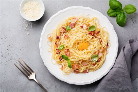 베이컨 치즈 계란 노 른 자 바 질와 파스타 스파게티 Carbonara 회색 빛 바탕에 나뭇잎 전통적인 이탈리아 요리입니다 최고의 볼 수 있습니다 가을에 대한 스톡 사진 및