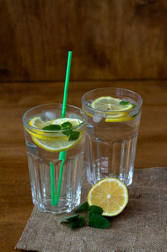 라임과 민트와 칵테일여름 음료 레몬과 신선한 잎 민트레모네이드 한 잔 소박한 나무 배경에 자루천이있는 수제 차가운 상쾌한 음료 또는 얼음으로 물 공간을 복사합니다 0명에