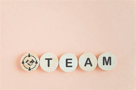 주황색 배경에 대상 아이콘과 단어 Team이있는 나무 큐브 블록 목표와 성공을 달성하기위한 작업 협력 목표 공통 목표 및 팀워크 개념에 도달하기위한 계획 시작 성취에 대한