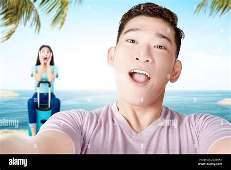 Asian Man Making Selfie With His Girlfriend On The Beach With Blue Sky