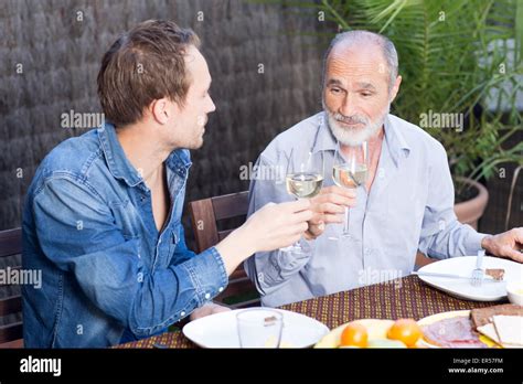 Father and son in garden drinking wine Stock Photo - Alamy