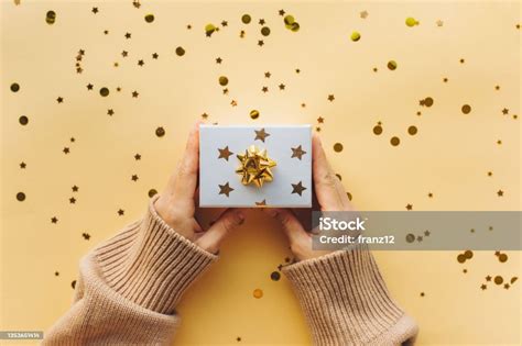 소녀는 손에 선물이 있는 상자를 들고 있다 인근 색종이와 금과 은 번호 2022 축제 새해와 크리스마스 개념 배경 2022년에