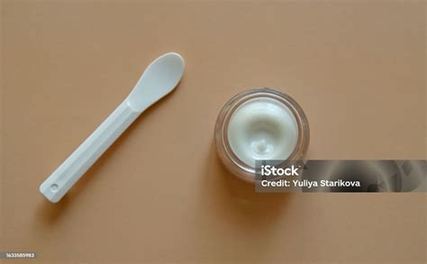 뷰티 크림의 플라스틱 병이나 파스텔 배경에 주걱으로 얼굴을 관리하기 위한 마스크 평면도 스킨케어 화장품 화장품 스파 의료 스킨 케어의 개념 천연 화장품 개념 각질제거 스크