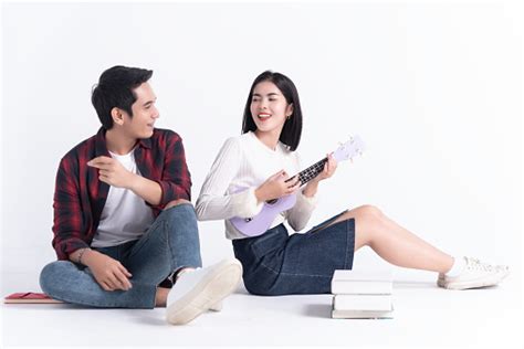 아름 다운 젊은 가정에서 부부 즐길 축 하 세인트 발렌타인의 날에 함께 시간을 보내고 여자 손 우쿨렐레 남자가 앉아와 미소 행복 하 고 모션을 사랑 기념일에 대한 스톡 사진