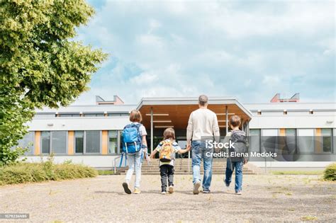 자녀 아들 딸을 학교에 데려다주는 행복한 부모의 뒤에서 바라본 모습 학교로 돌아 가기 아버지가 자녀를 돌보는 일 10 11세에 대한 스톡 사진 및 기타 이미지 Istock