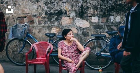 보라색과 흰색 꽃 드레스를 입은 여성이 야외에서 빨간 플라스틱 안락 의자에 앉아 있습니다 사진 Unsplash의 무료 의자 이미지