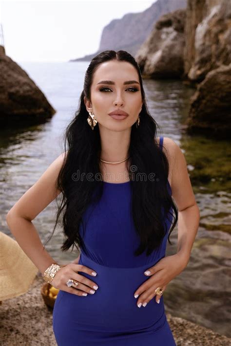 Beautiful Woman With Dark Hair In Elegant Blue Dress Posing On The