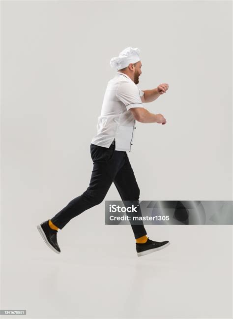 흰색 배경에 고립 된 부엌으로 달리는 제복을 입은 요리사의 초상화 직업 직업 유머의 개념 남자에 대한 스톡 사진 및 기타 이미지