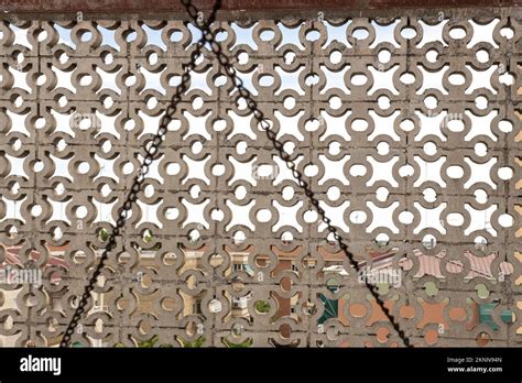 Some Rusty Chains Forming A Cross With A Cement Lattice With White Colors And Between The
