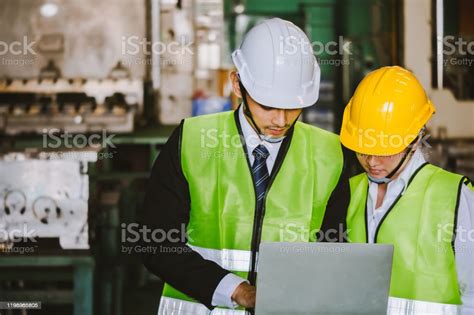 아시아 여성 엔지니어 공장 검사 와 남자 사업 들고 태블릿 컴퓨터 엔지니어 산업 우리는 헬멧 여성 작업 금속 작업 제어 산업에서 자동차 플라스틱 공장에서 Stem 주제에