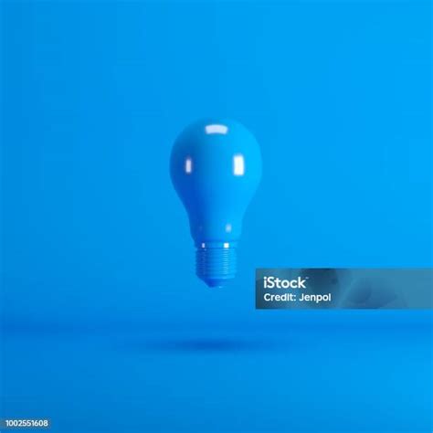 파란색 배경 색상에 최고의 네일 트랩에 떠 있는 파란 전구 뜨는 서핑 최소한의 아이디어 개념입니다 전구에 대한 스톡 사진 및