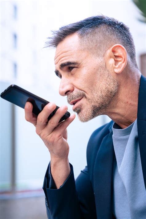 Businessman Using Voice Command On Smartphone Outdoorsvertical Stock