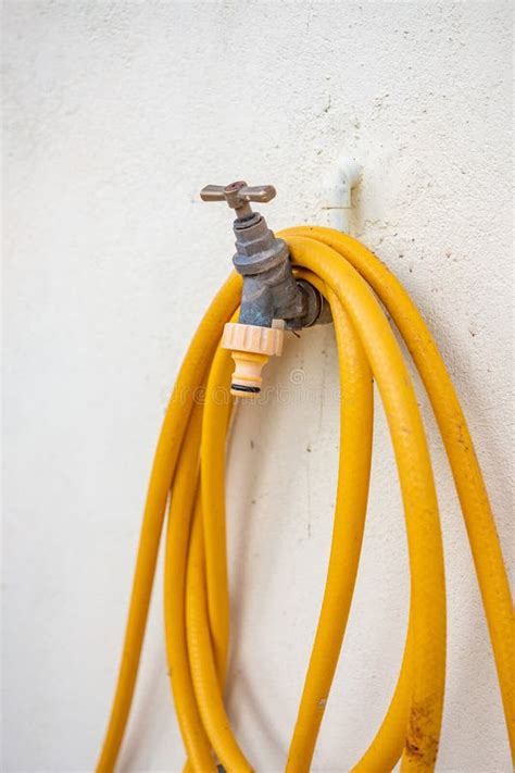 Outdoor Tap And Garden Hose Suspended On An Exterior Wall Stock Image