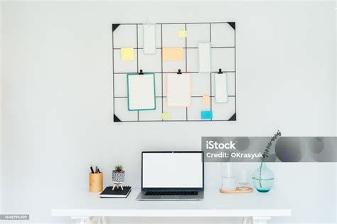 현대 직장 노트북 모형 빈 화면이 있는 흰색 책상 고정된 메모와 계획 체크리스트가 있는 그리드 무드 보드 홈 오피스 룸 인테리어의 작업 공간에 있는 사무용품 0명에 대한