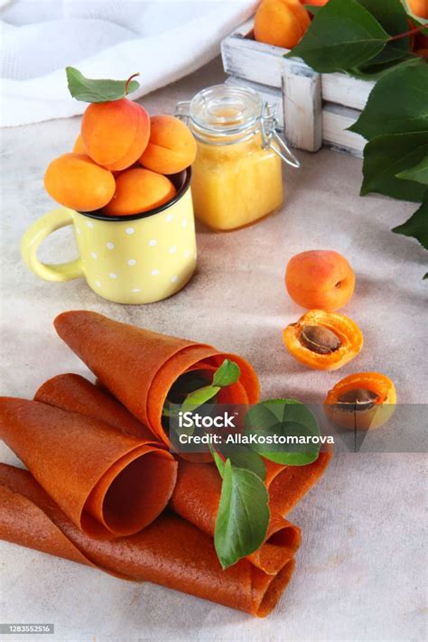 살구 파스티유는 흰색 배경에 튜브로 굴러 흰색 나무 상자와 세라믹 머그잔에 살구 꿀을 첨가한 천연 제품 저칼로리 식사와 스낵 세로 사진 건강한 식생활에 대한 스톡 사진 및