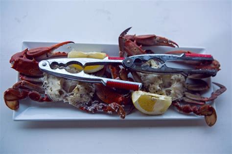 Premium Photo Cut Boiled Blue Crab Lies On A White Plate With Tongs