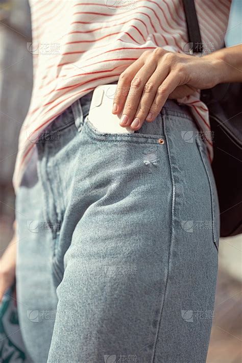 年轻苗条的女孩把智能手机放进口袋素材 花瓣网