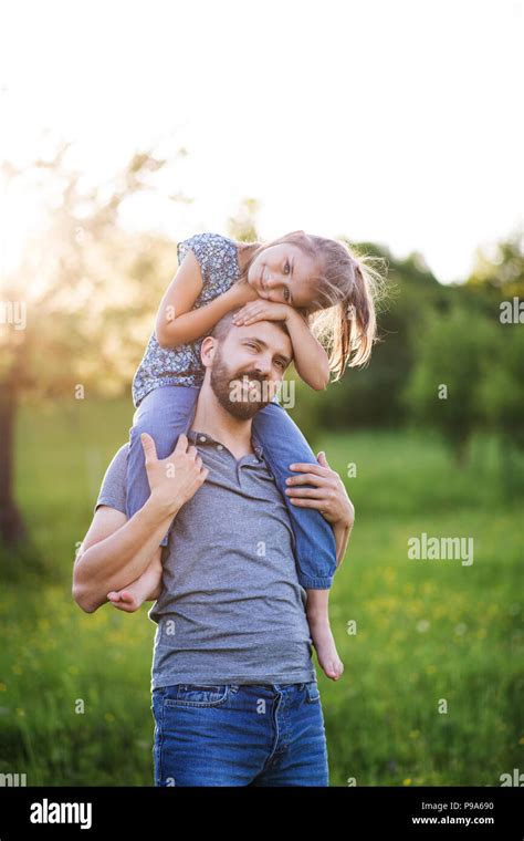 Father Giving Small Daughter A Piggyback Ride In Spring Nature Stock