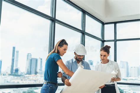 Group Of Engineer Looking At Project Plan While Brainstorming Idea