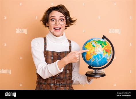 Photo Portrait Of Excited Smart Female Nerd Pointing Finger At Globe In Glasses Isolated On