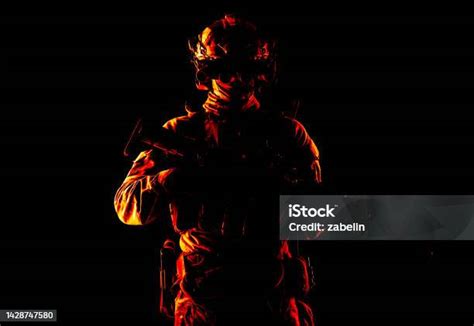 절반 길이 육군 병사의 낮은 키 스튜디오 촬영 마스크의 해양 보병 카모 유니폼 장착 된 현대 탄약 헬멧에 야간 투시경 장치로 어둠 속에 서있는 무장 서비스 소총 25 29