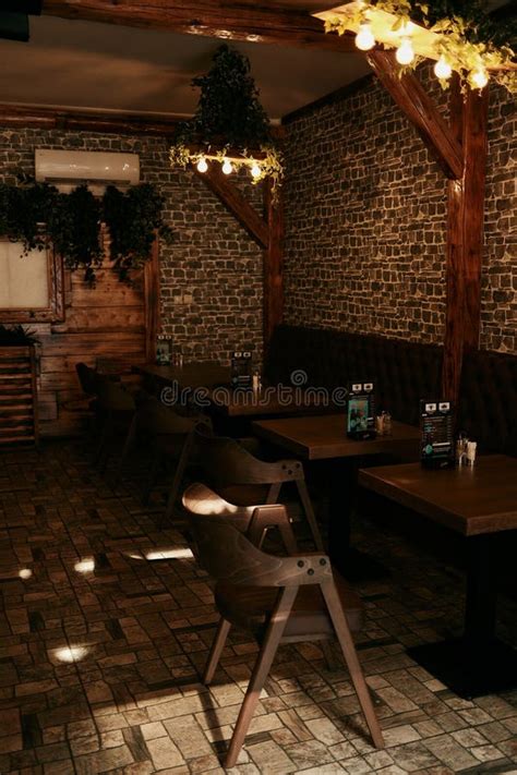 Cozy Restaurant Interior With Wooden Tables Chairs And Warm Light