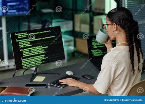 Female It Programmer Drinking Tea While Using Computer For Writing Code