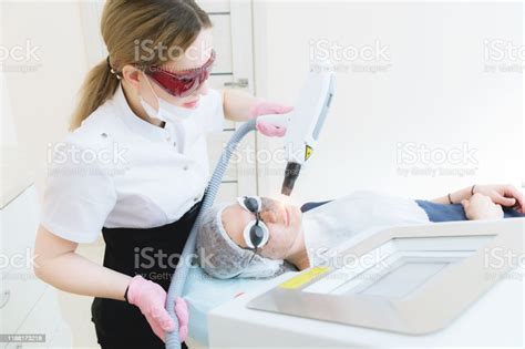 고글의 미용사 소녀는 미용 레이저의 도움으로 탄소 박리 절차를 만듭니다 탄소 면 박리 절차 레이저 펄스 얼굴의 깨끗한 피부 건강