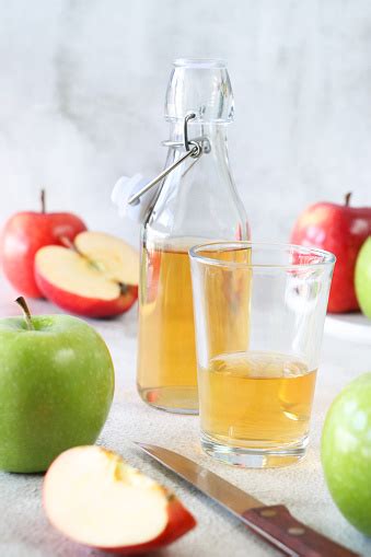 빨간색 Honeycrisp와 녹색 Granny Smith 사과 전체 반으로 자른 과일 칼 흰색 배경 건강 및 웰빙 개념으로 둘러싸인 음료수 잔에 사과 사이다 식초가 들어있는