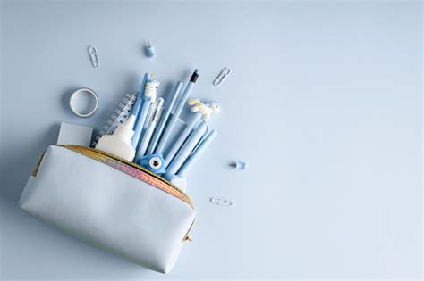 연필 케이스와 연한 파란색 배경에 다양한 파란색 문구가있는 배경 학교로 돌아 가기 텍스트를위한 공간이있는 사무실 요소가있는 배너 공간을 복사합니다 플랫 레이 상단 뷰 0명에