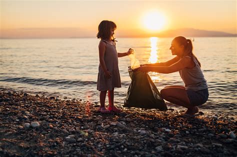 환경 보호 어머니와 딸은 일몰 동안 쓰레기에서 해변을 청소합니다 물가에 대한 스톡 사진 및 기타 이미지 물가 플라스틱 오염 흙 Istock