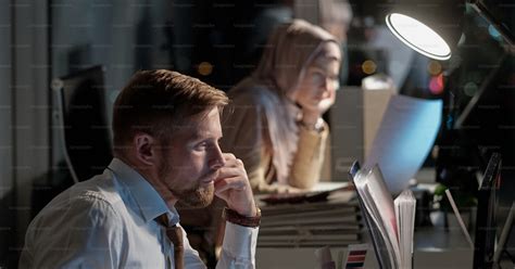 젊은 우아한 남성 경제학자가 무슬림 여성 동료에 대해 사무실에서 책상에 앉아 컴퓨터 화면을 보고 있다 사진 Unsplash의 동료 이미지