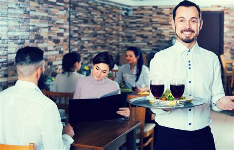 Portrait Of Adults In Middle Class Restaurant And Smiling Waiter Stock