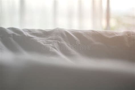 Closeup Of Beautiful White Shiny Crumpled Fabric Sheets On The Bed