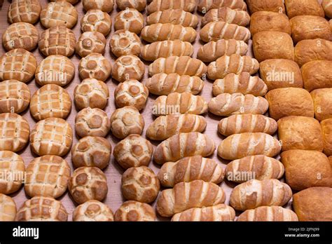 Various Types Of Bread Buns Displayed Orderly On Top Of A Wooden Display Stand From An Italian