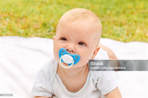 화창한 여름날 야외에서 잔디밭에 담요에 엎드려 누워 있는 귀여운 갓 태어난 소녀 야외에서 즐거운 시간을 보내는 유아 유아 아기 아이는 기어 다니는 법을 배우며 쉬고 있다