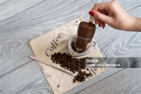 유리 컵에 담긴 강한 블랙 커피 에스프레소 테이블 위에 놓인 커피 냅킨에 긴 숟가락과 커피 원두 커피 한 잔에 초콜릿 아이스크림을 붓는 여자 손 여름 다과 아포가토 커피