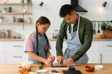 Genitore Che Insegna Al Figlio A Fare Il Sushi Foto Gratis