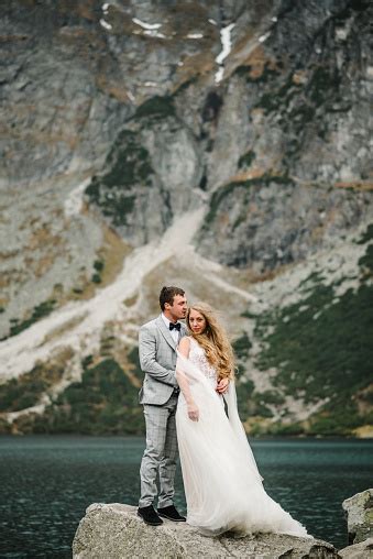폴란드의 바다 눈 호수의 돌 해안에 서 사랑에 낭만적 인 결혼식 커플 경치 좋은 산전망 신부와 신랑 모르스키 오코 타트라 산맥 2명에 대한 스톡 사진 및 기타 이미지