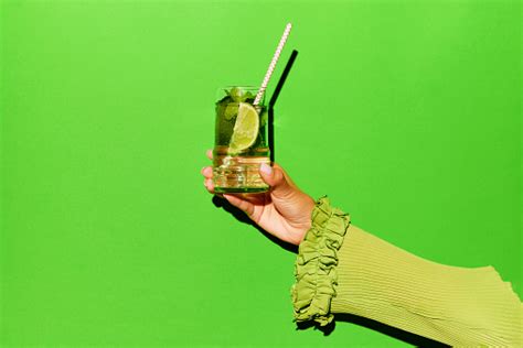 독점적 인 알코올 음료 밝은 녹색 배경 위에 라임이 있는 진 토닉 칵테일이 있는 유리잔을 들고 있는 여성의 손 마실 것에 대한 스톡 사진 및 기타 이미지 Istock