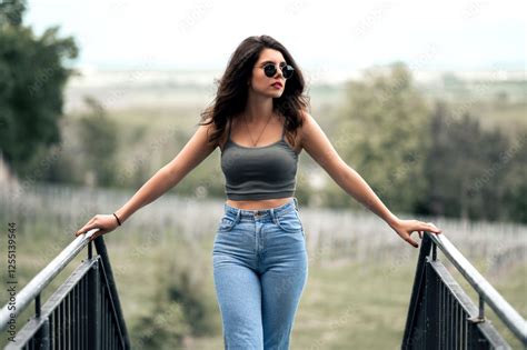 Photo Of Beautiful Girl In Blue Jeans And Khaki Top Sexy Woman Posing Woman On Metal Stairs