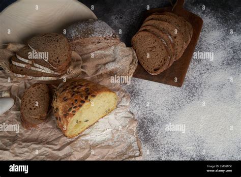Different Types Of Sliced Bread And A Loaf On A Wooden Background Spilled Flour High Angle