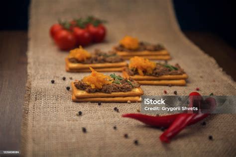 자루와 나무 배경에 토마토와 칠리 페퍼를 곁들인 가금류 파테가 있는 크래커 몇 개 0명에 대한 스톡 사진 및 기타 이미지 0